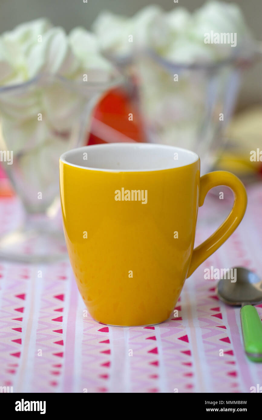Tea in yellow cup with candy for breakfast Stock Photo - Alamy