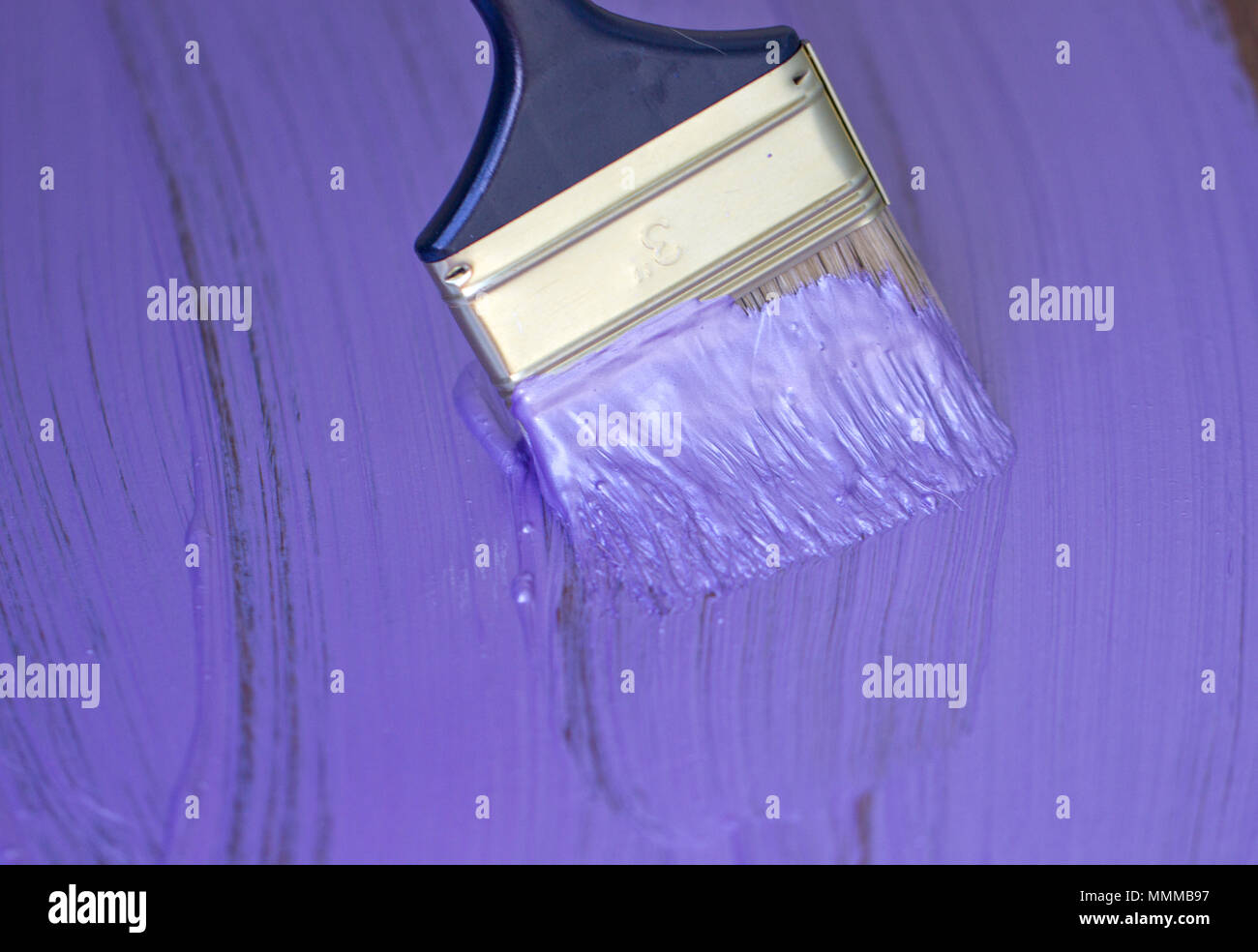 Brush with purple paint and hand Stock Photo - Alamy