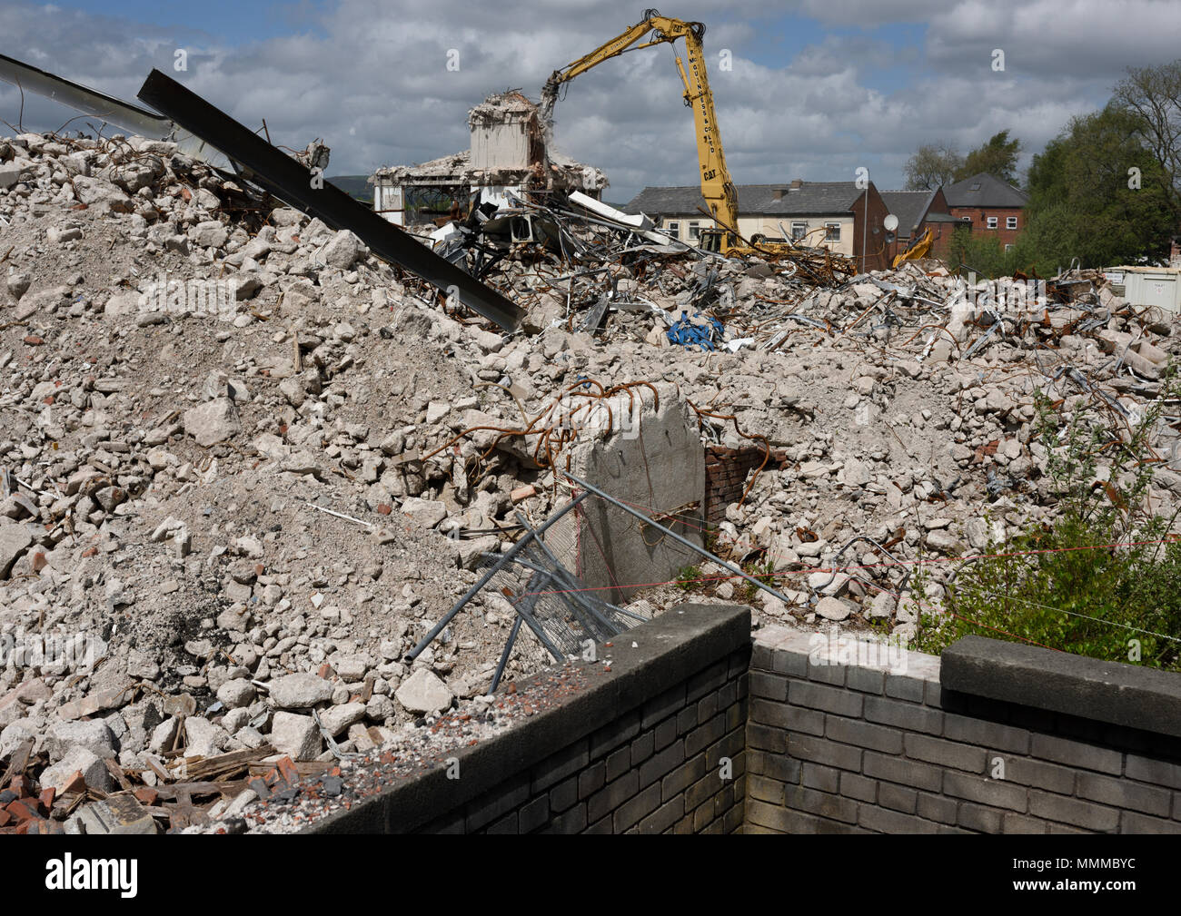 Concrete rubble and waste on and brick wall on demolition site with ...
