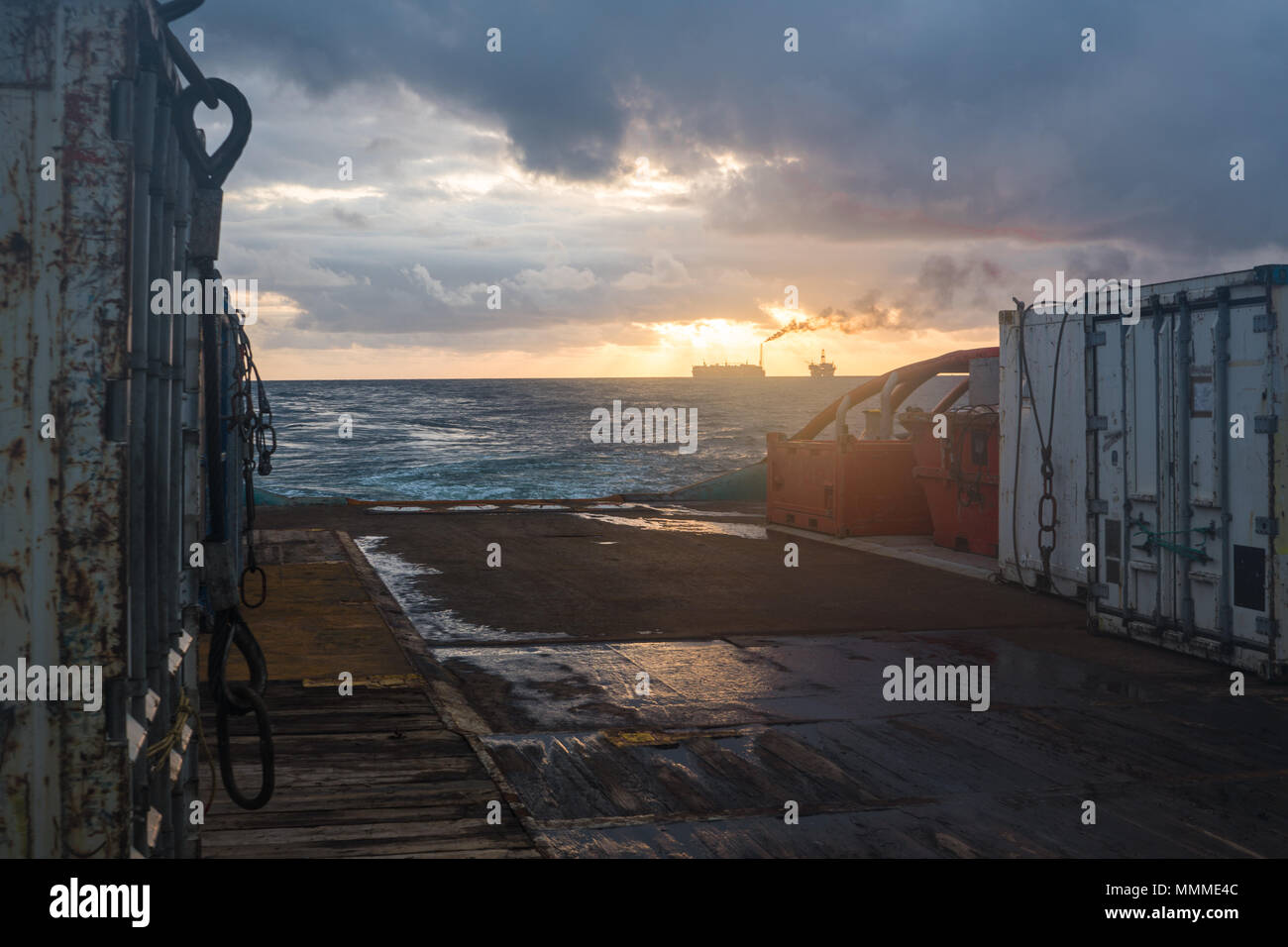 View on cargo deck with containers of offshore supply vessel. Sunset ...