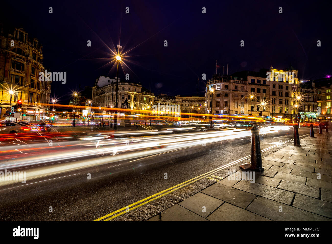 Cars and buses cause streaks across the night sky in front of Trafalgar ...