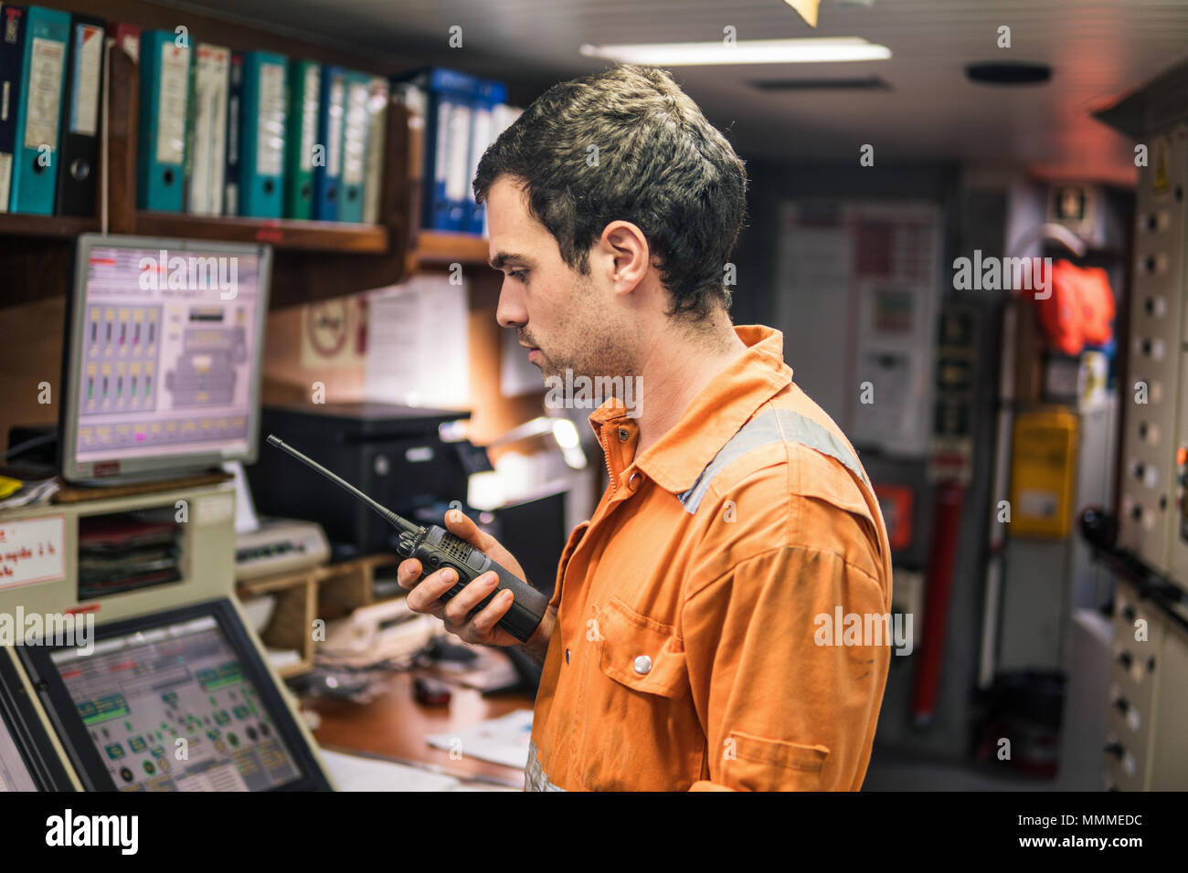 Marine Engineer working on radio communication at Engine Control room ...