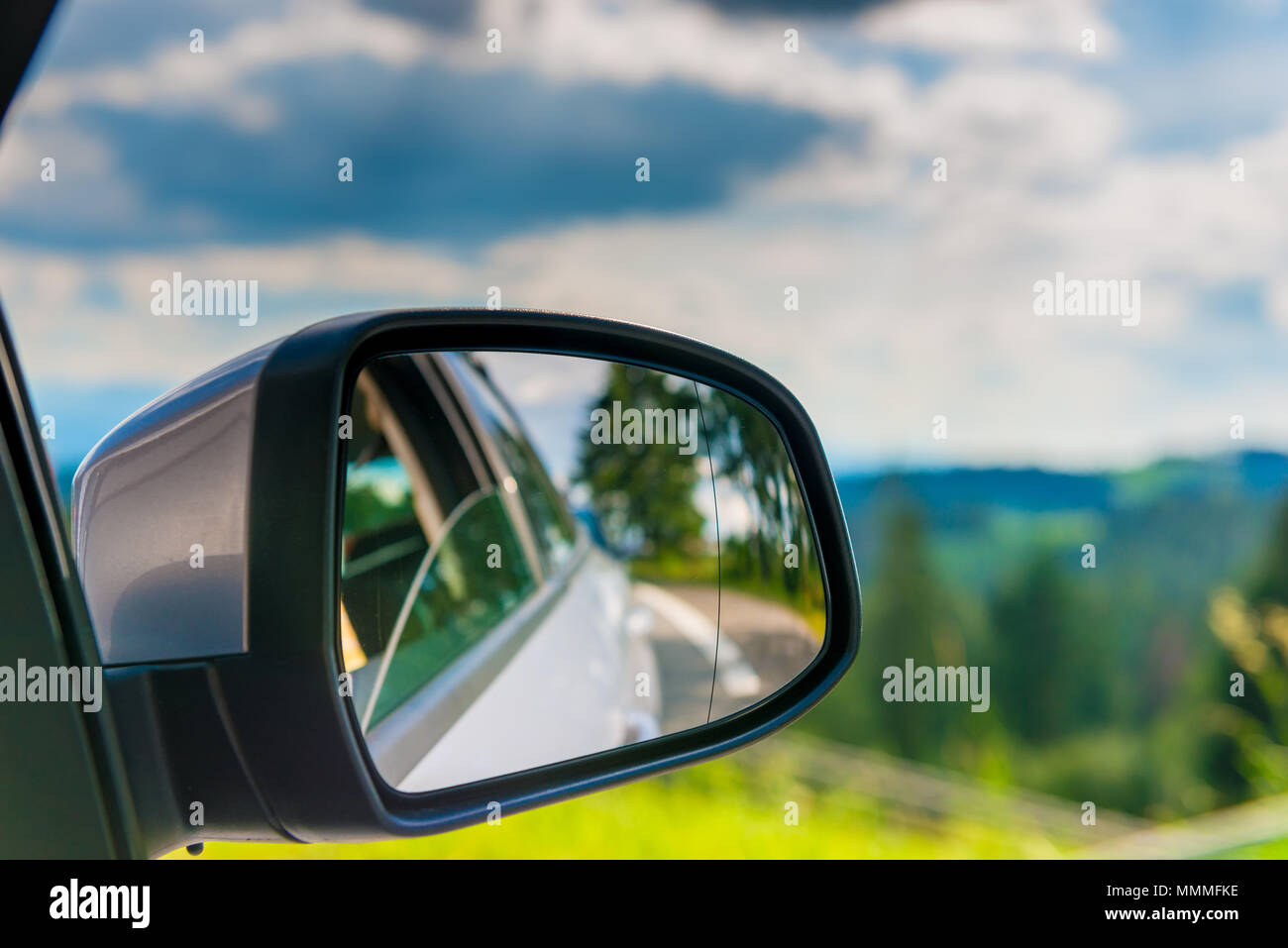 car mirror with reflection of a beautiful landscape in it, close-up ...