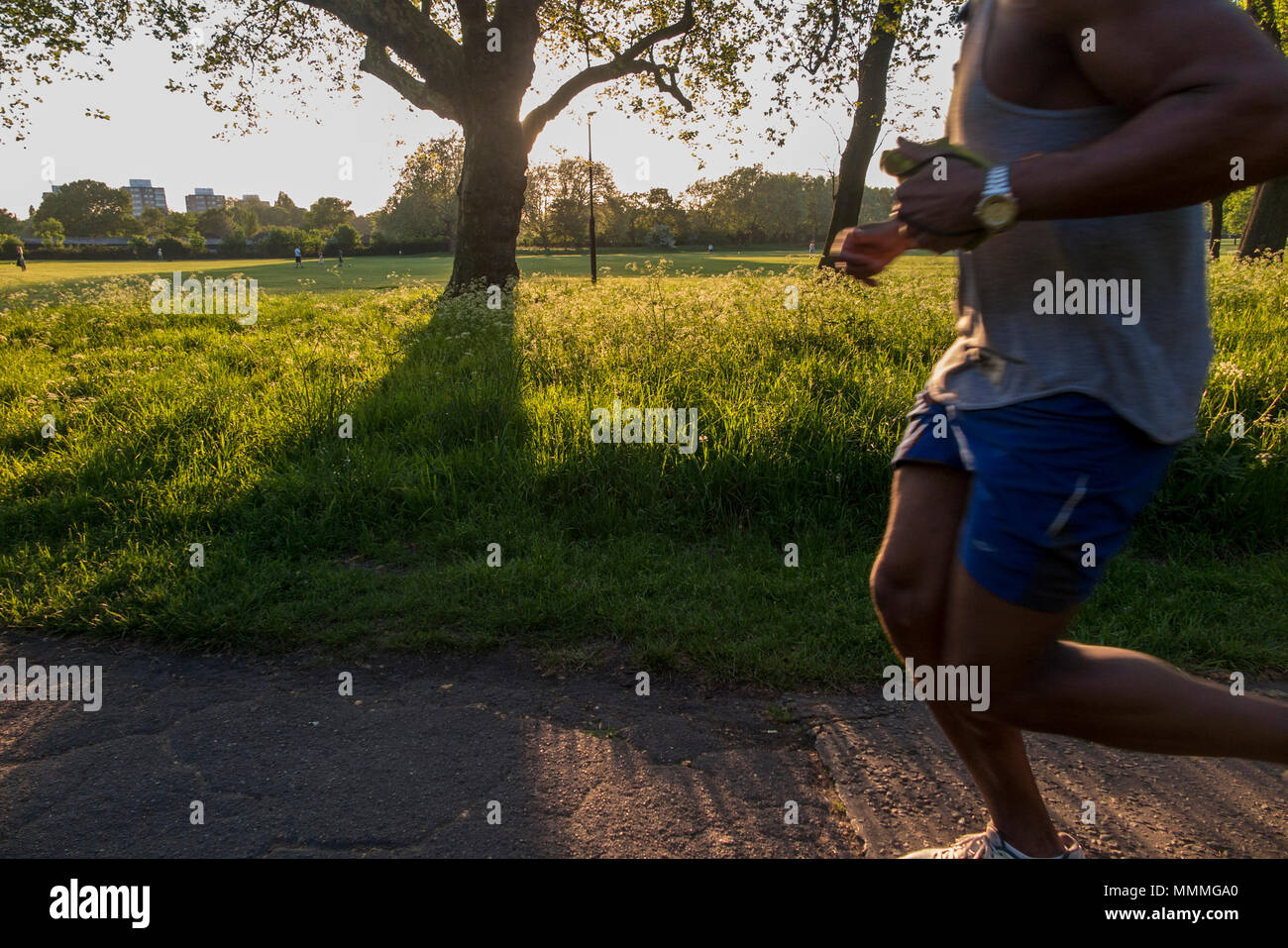 A cropped picture of a man running in a London park at dusk Stock Photo ...