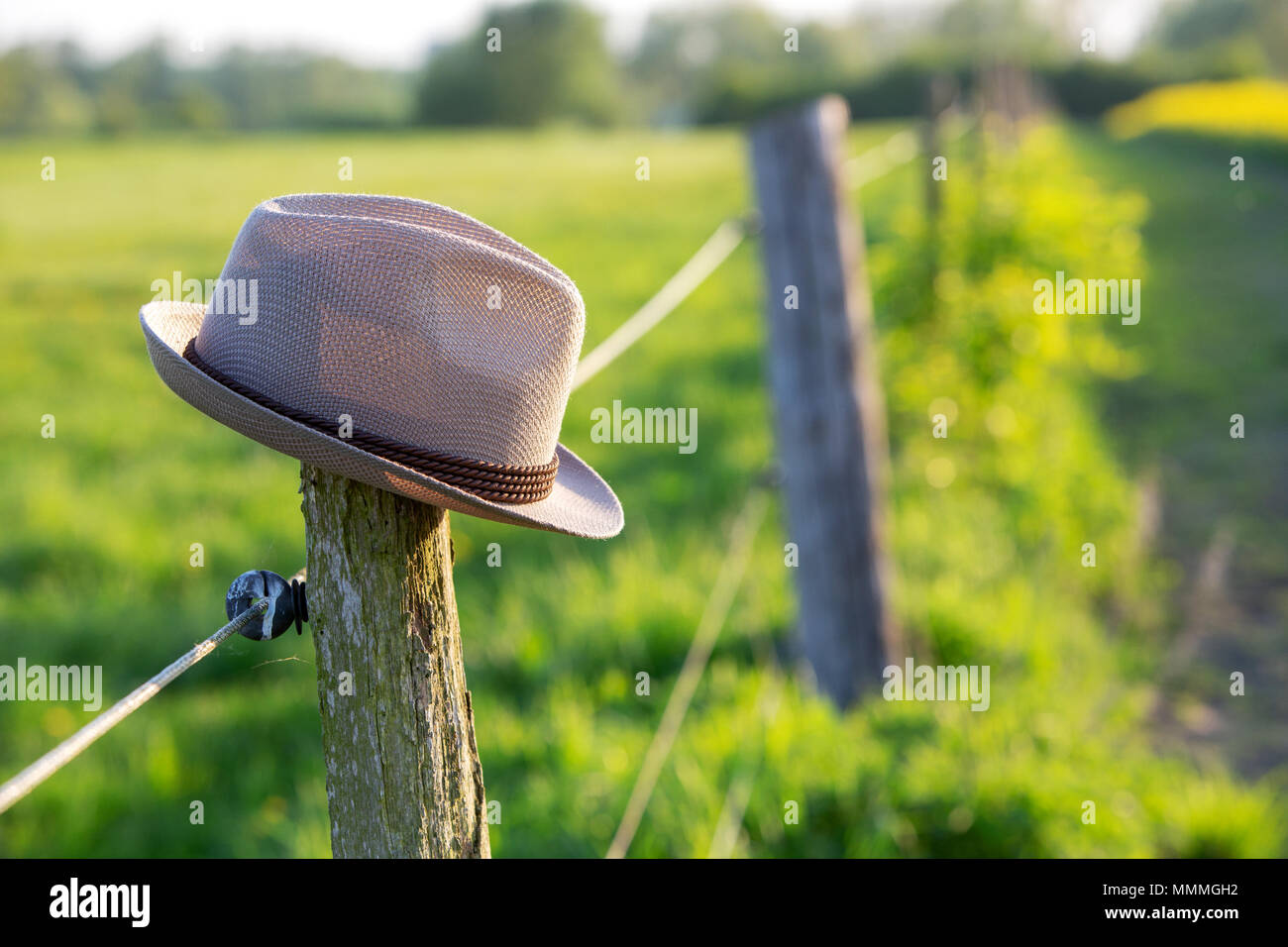 hat on top of a fence post in the fields Stock Photo - Alamy
