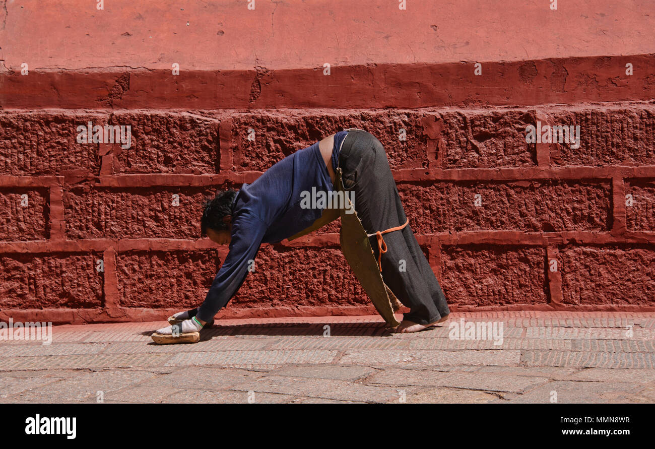 Tibetan pilgrims doing prostrations around the holy Bakong Scripture ...