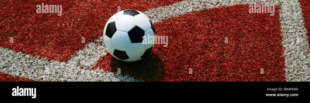 soccer ball on red ground, panoramic format, landcape format on corner ...