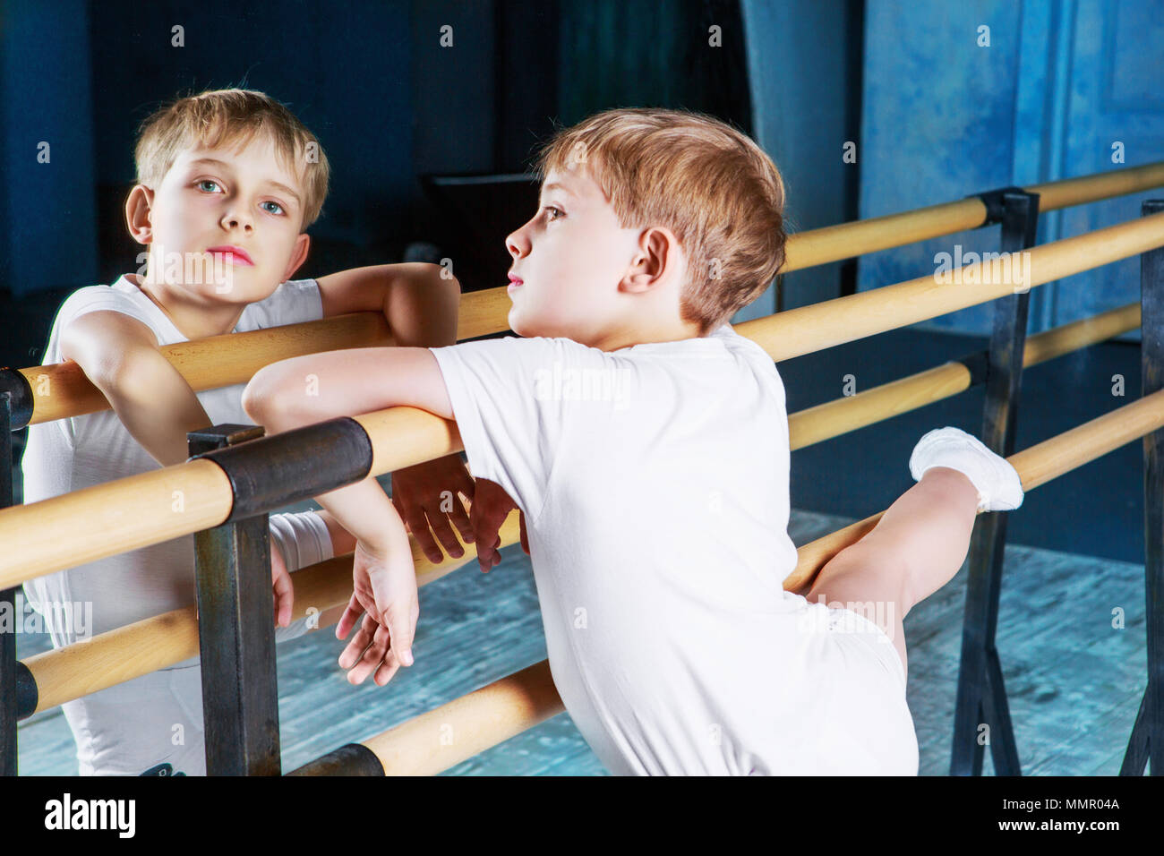 boy ballet dancer doing exercise at dance class near the barre indoors ...