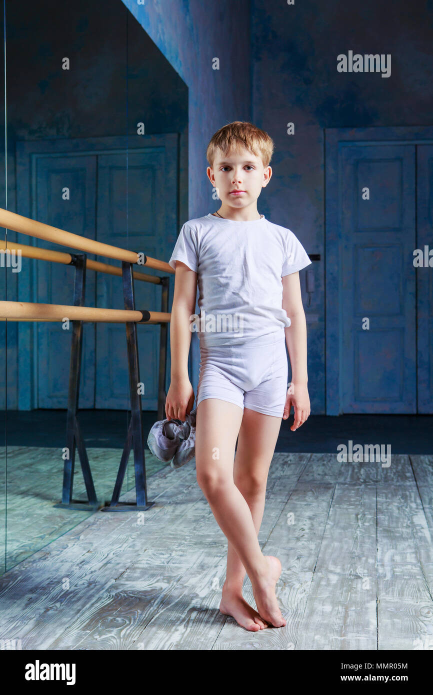 boy ballet dancer posing with pointes in his hands at dance class near ...