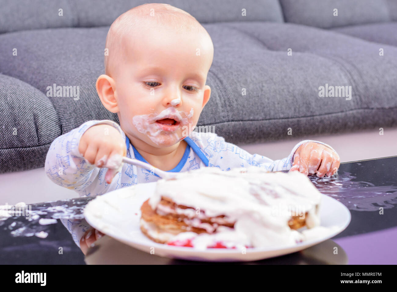 First birthday celebration of a little boy. Little boy eating birthday ...