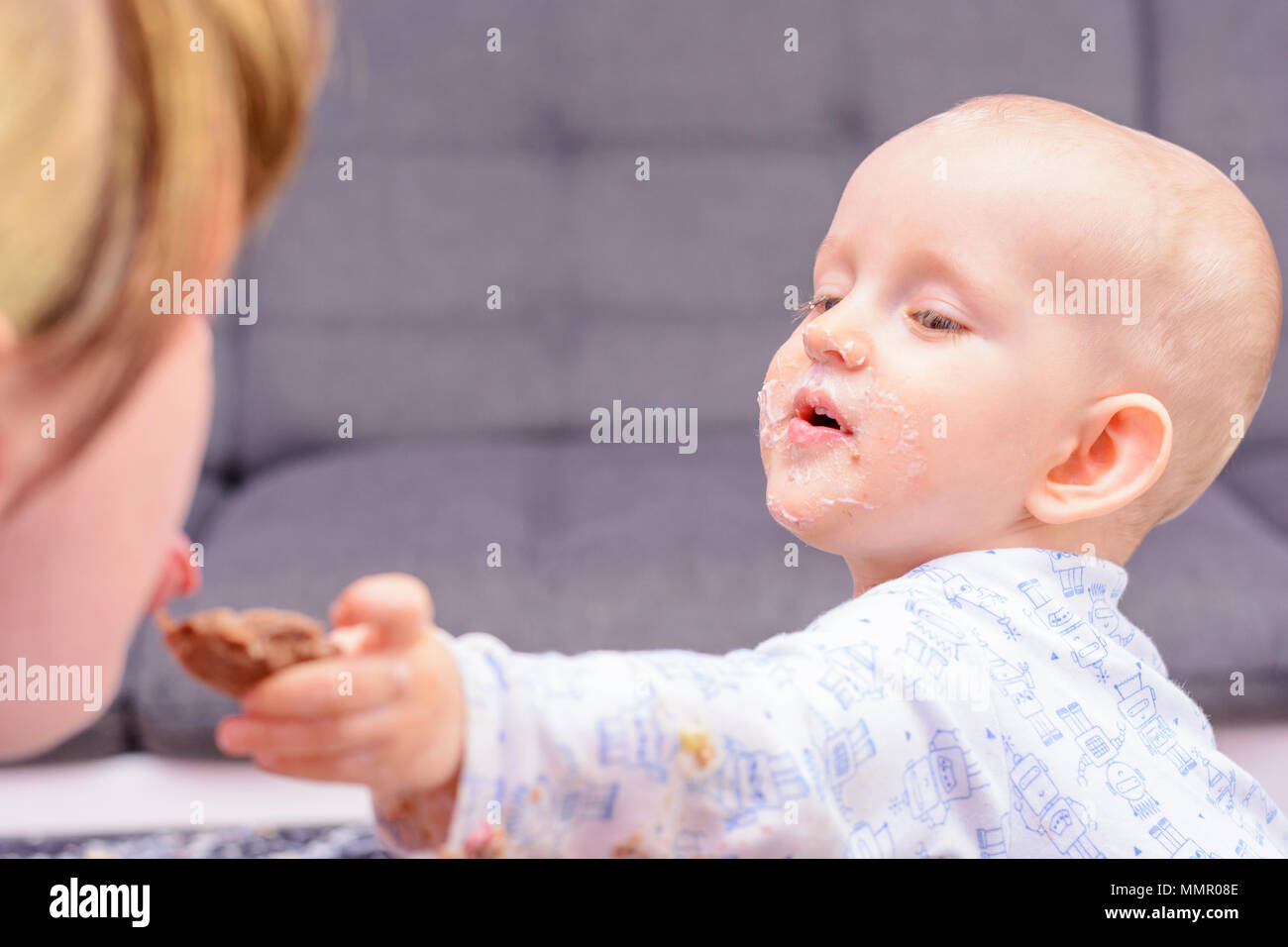 Small child gives a taste of the cake your mother. First birthday ...