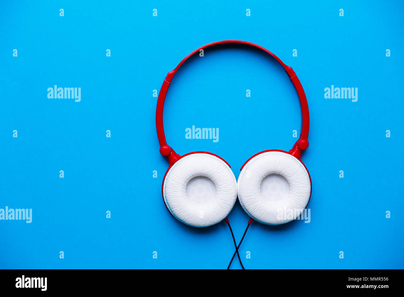 Photo of red with white headphones on empty blue background Stock Photo ...