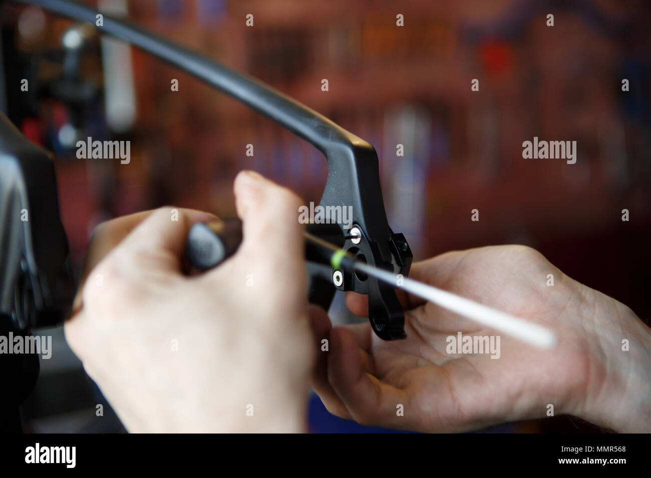 Image of man mending part of bicycle in workshop. Defocused background ...