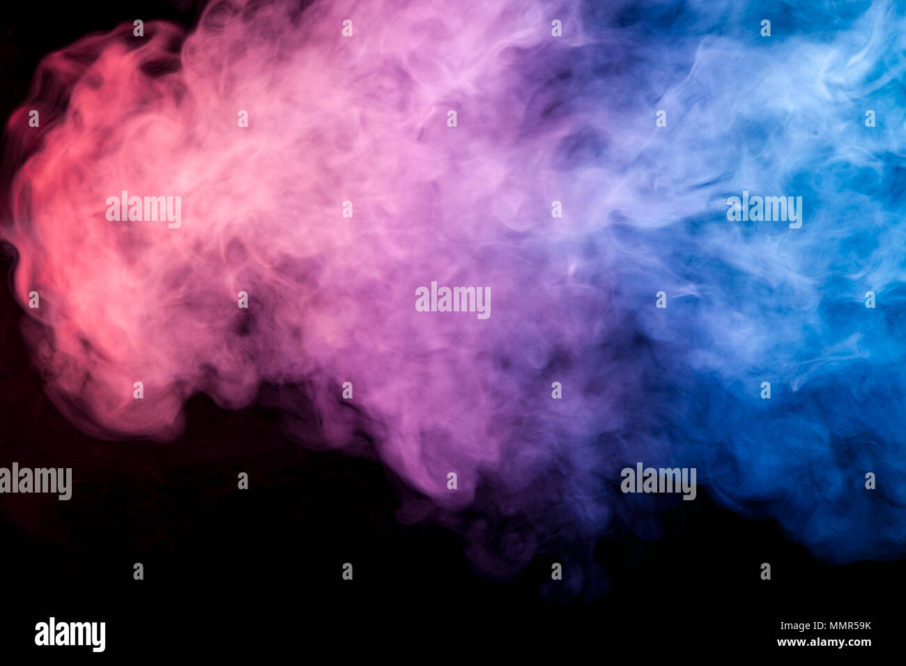 Thick colorful pink and blue smoke on a black isolated background ...