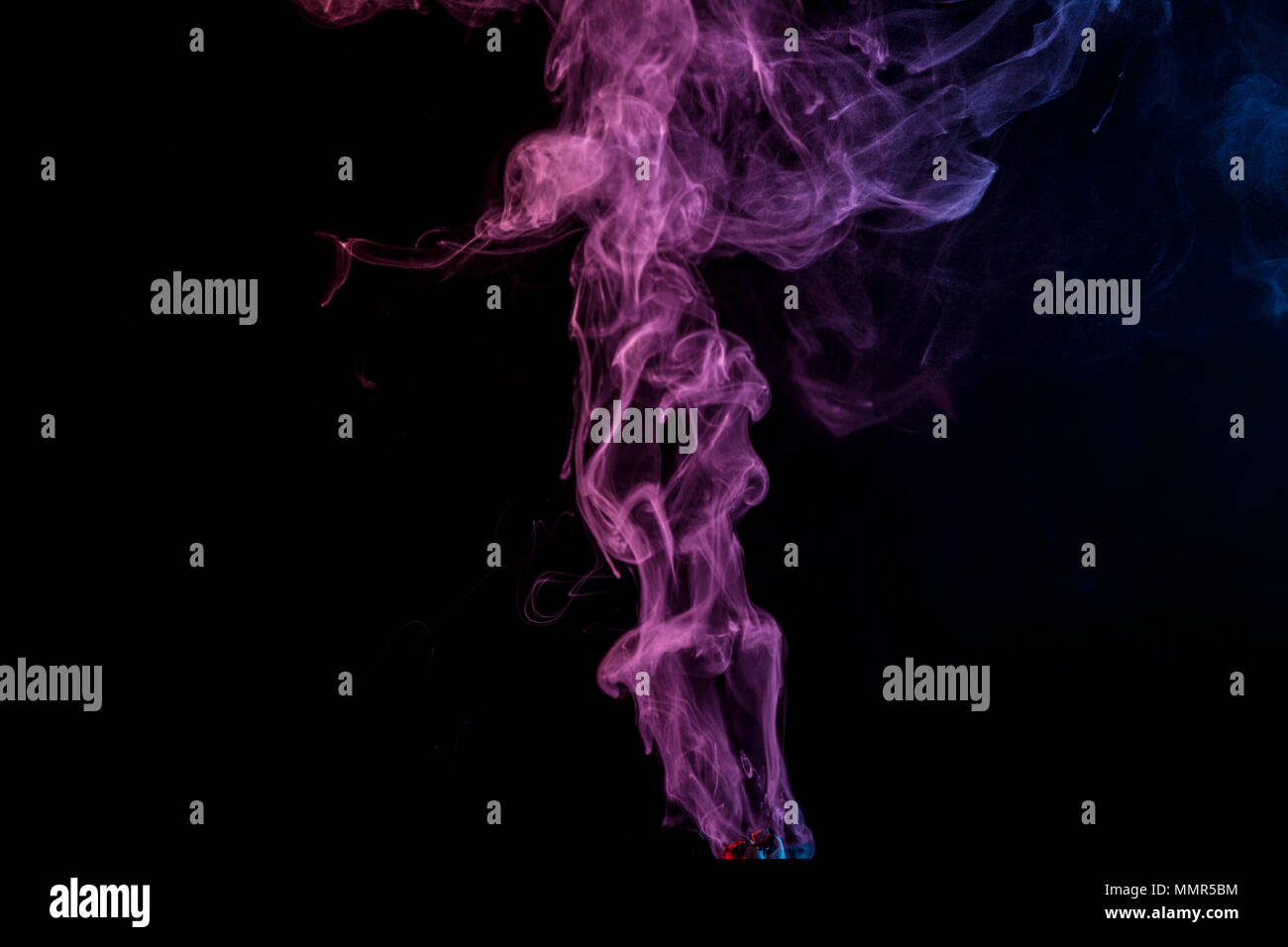 Thick colorful purple smoke on a black isolated background. Background ...