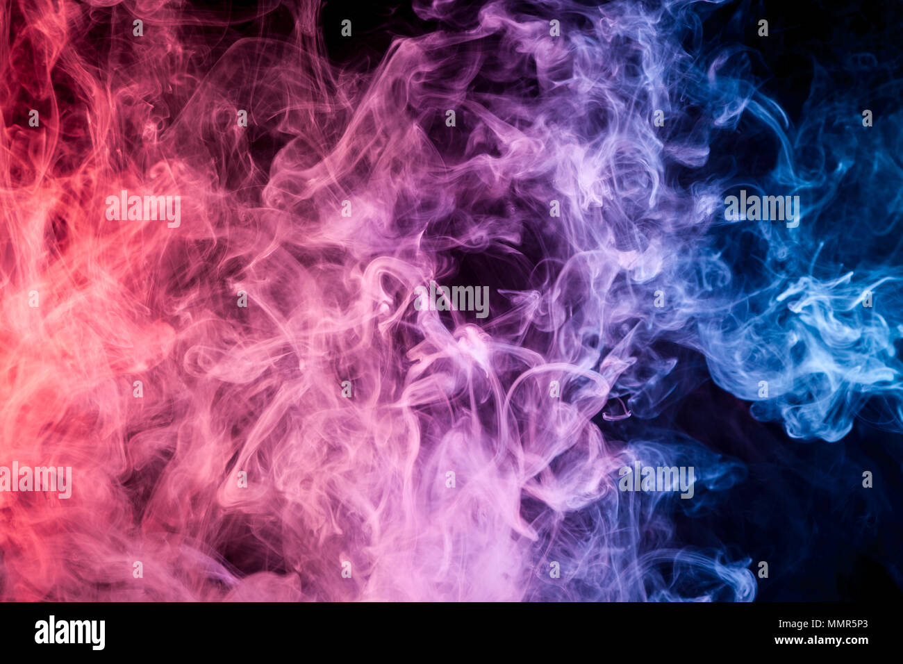 Colorful pink, blue and red smoke on a black isolated background ...