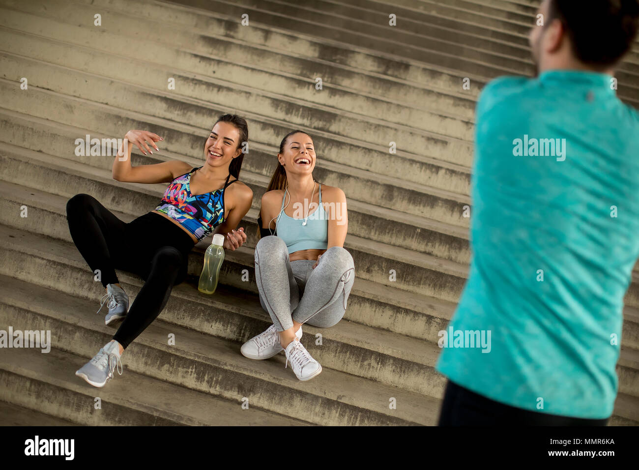 Portrait of young runners resting on stairs after the training Stock ...