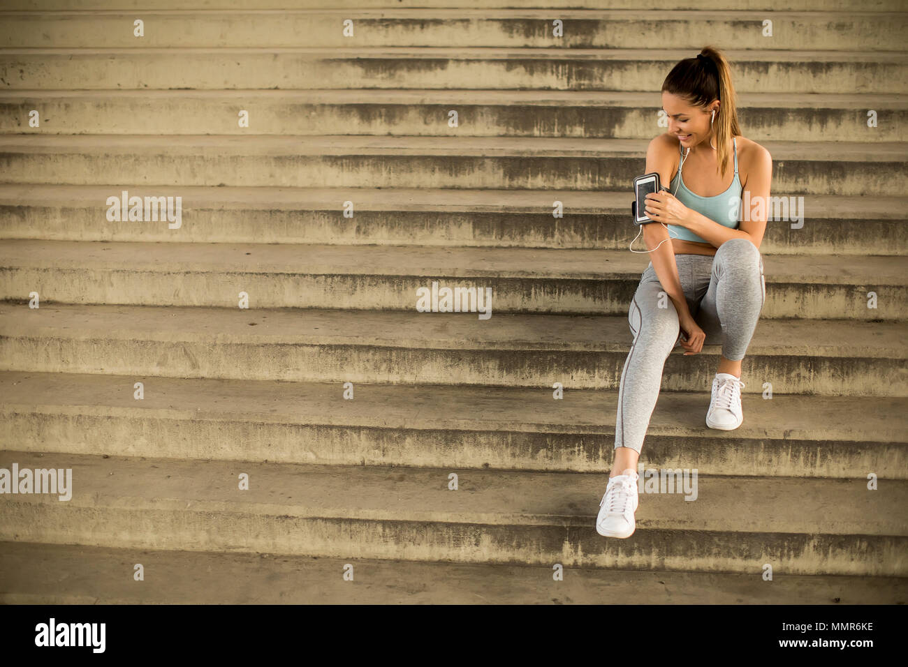Portrait of pretty young female runner resting on stairs Stock Photo ...