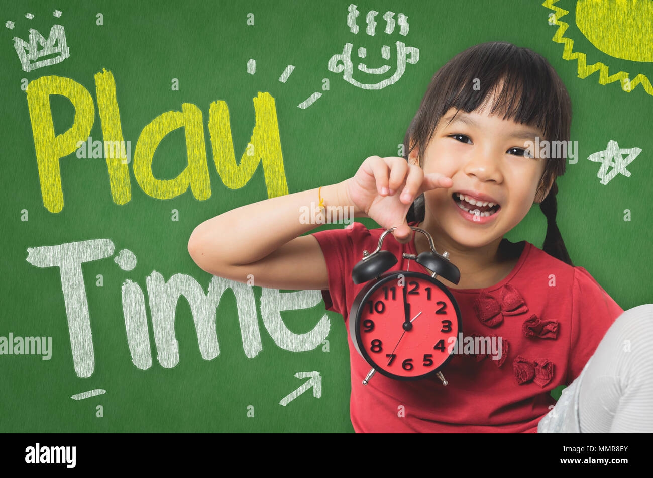 Little girl is holding a clock ready for playtime Stock Photo - Alamy