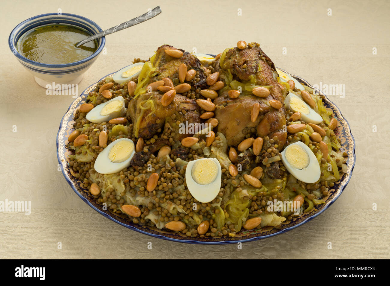 Traditional Moroccan Rfissa dish with eggs, almonds and a bowl with ...