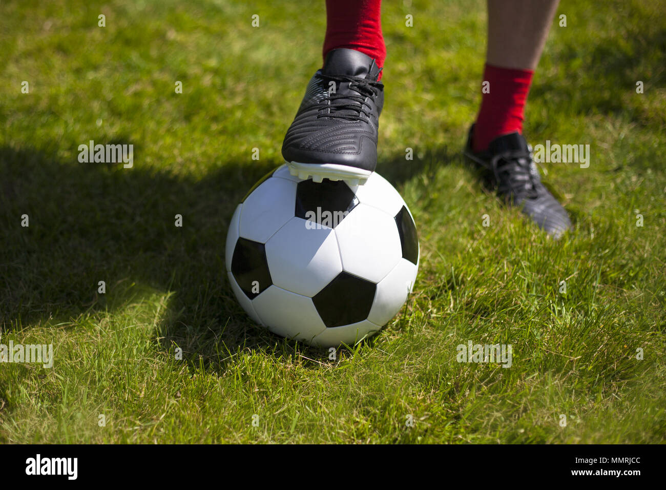 A footballer's boot and sock on top of a black and white leather ...