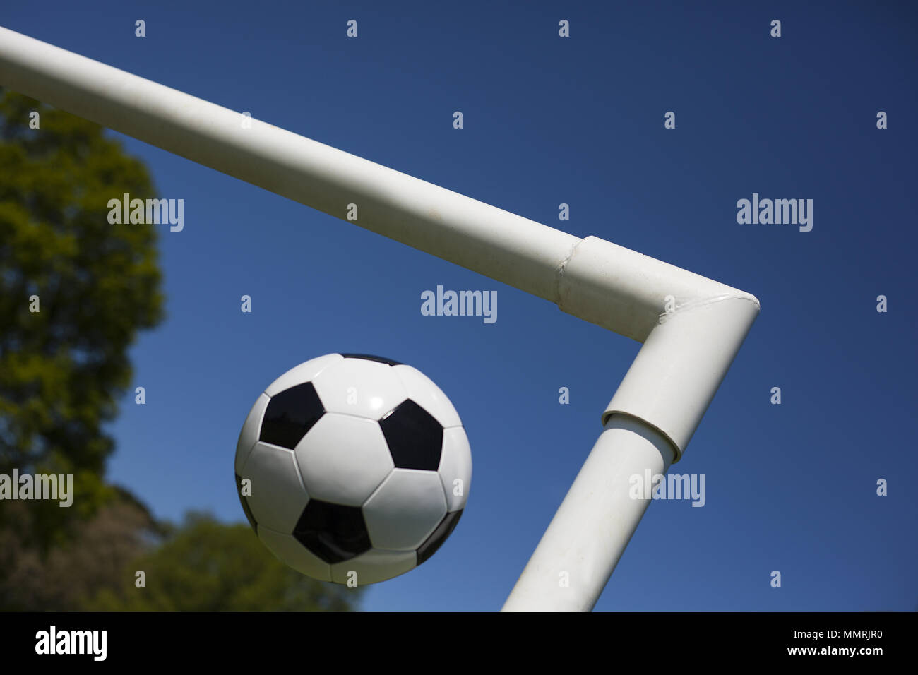 A black and white leather football at the cross of the goal posts Stock ...