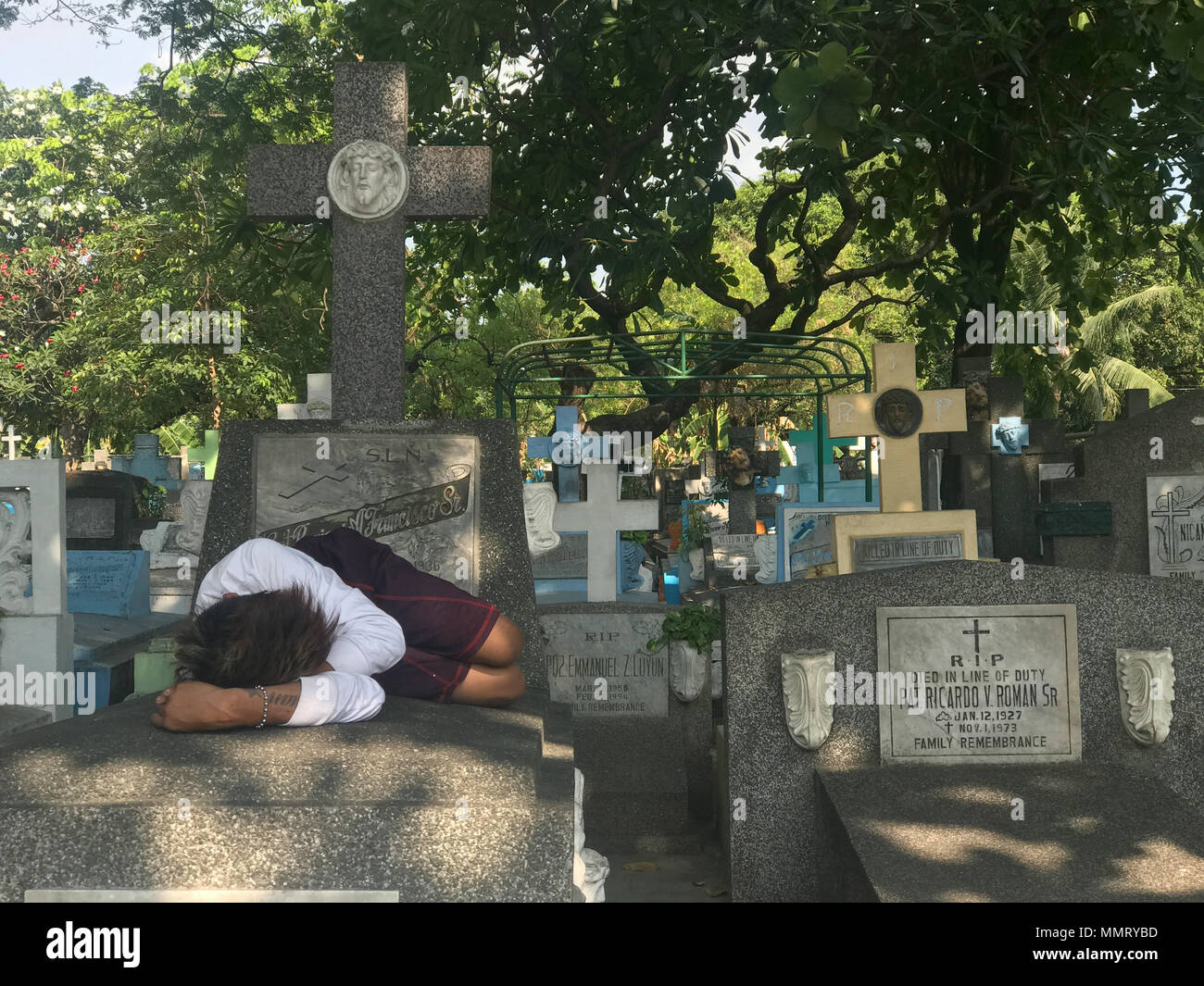 20 April 2018, Philippines, Manila: A boy sleeps on a grave in the ...