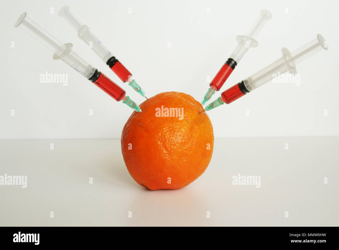 Organic and non organic fruit. Fruit and syringe on it Stock Photo - Alamy