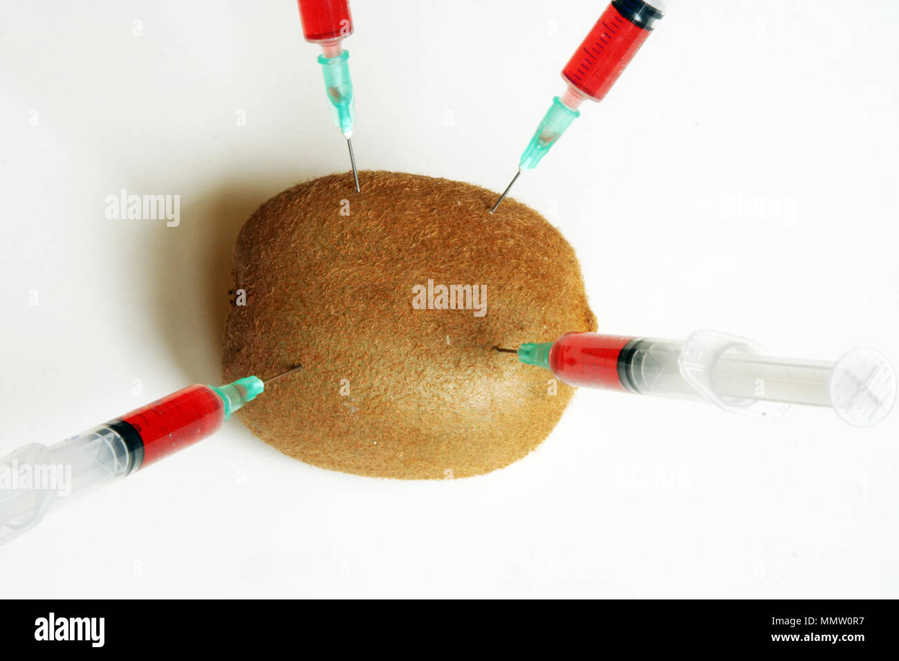 Organic and non organic fruit. Fruit and syringe on it Stock Photo - Alamy