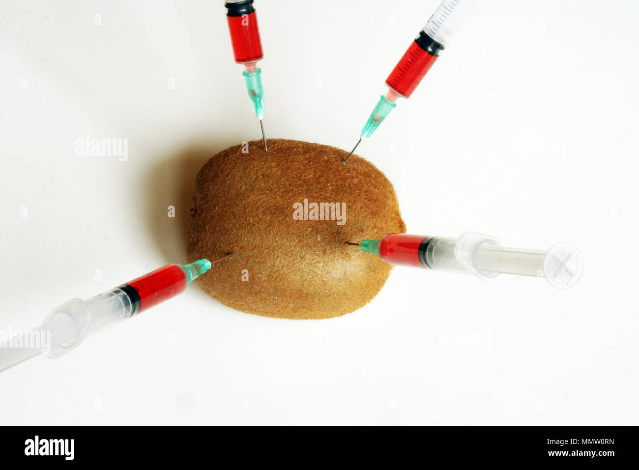 Organic and non organic fruit. Fruit and syringe on it Stock Photo - Alamy