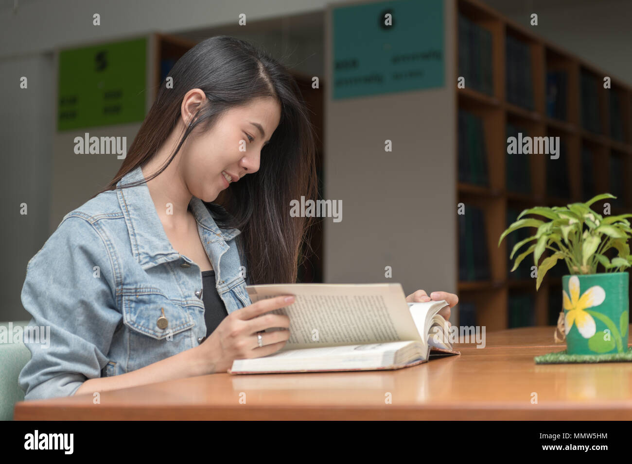young student reading book it in university library, learning and ...