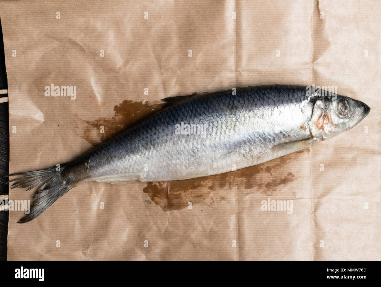 Salted dry fresh herring fish on an paper bag background. Rustic style ...