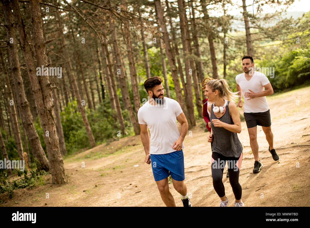 Group of young people run a marathon through the forest Stock Photo - Alamy