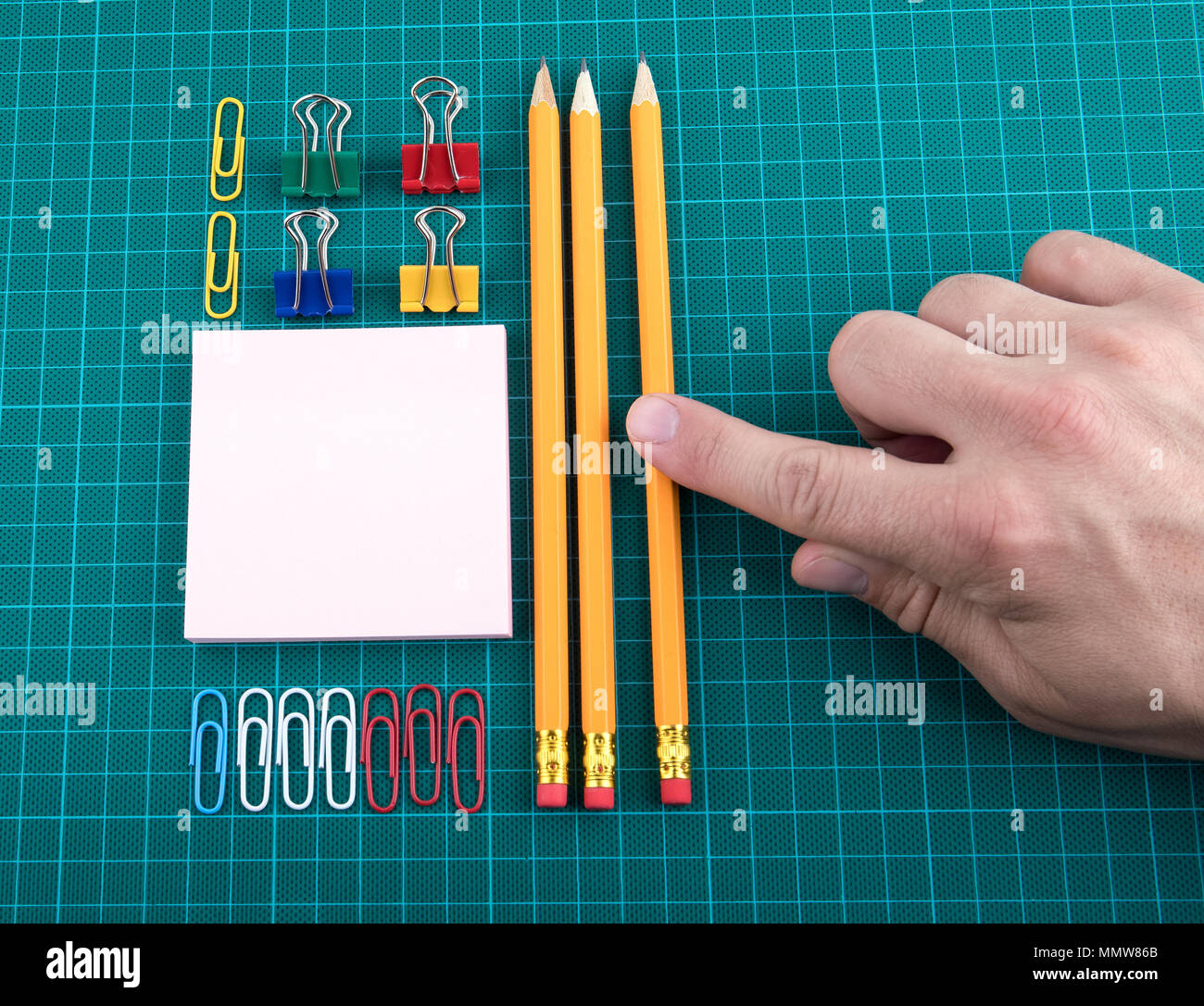 Paper clips, pencils and note sheet on checked green backgound Stock ...