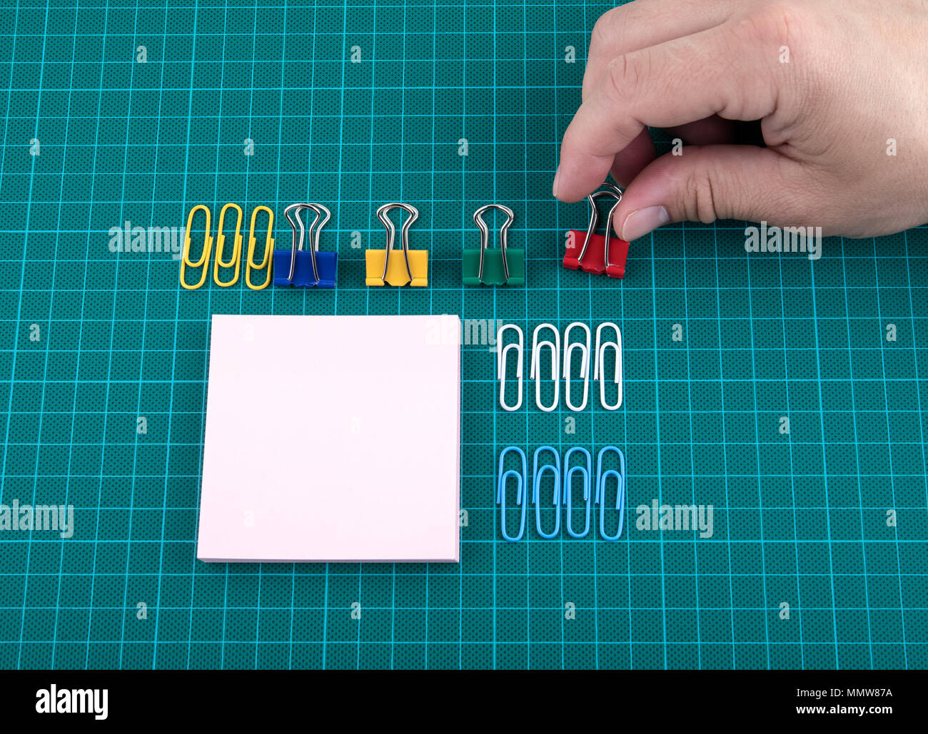 Paper clips and note sheet on checked green backgound Stock Photo - Alamy