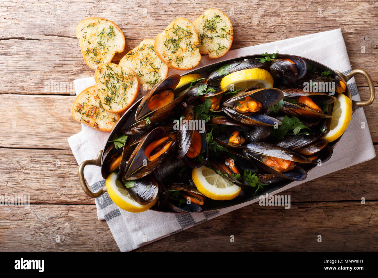 Copper pot of gourmet mussels with lemon, parsley and garlic served on ...