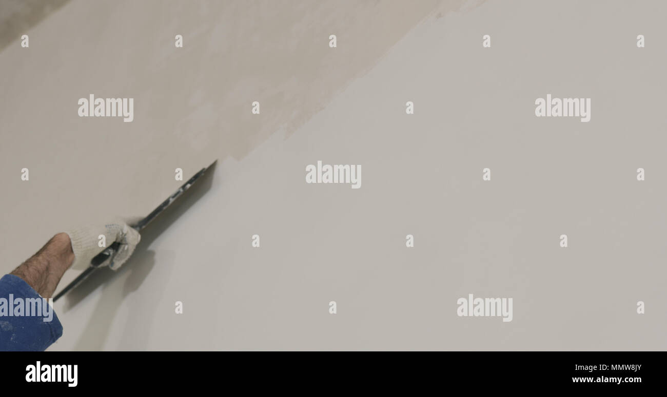 worker applying putty on the wall, wide photo Stock Photo - Alamy