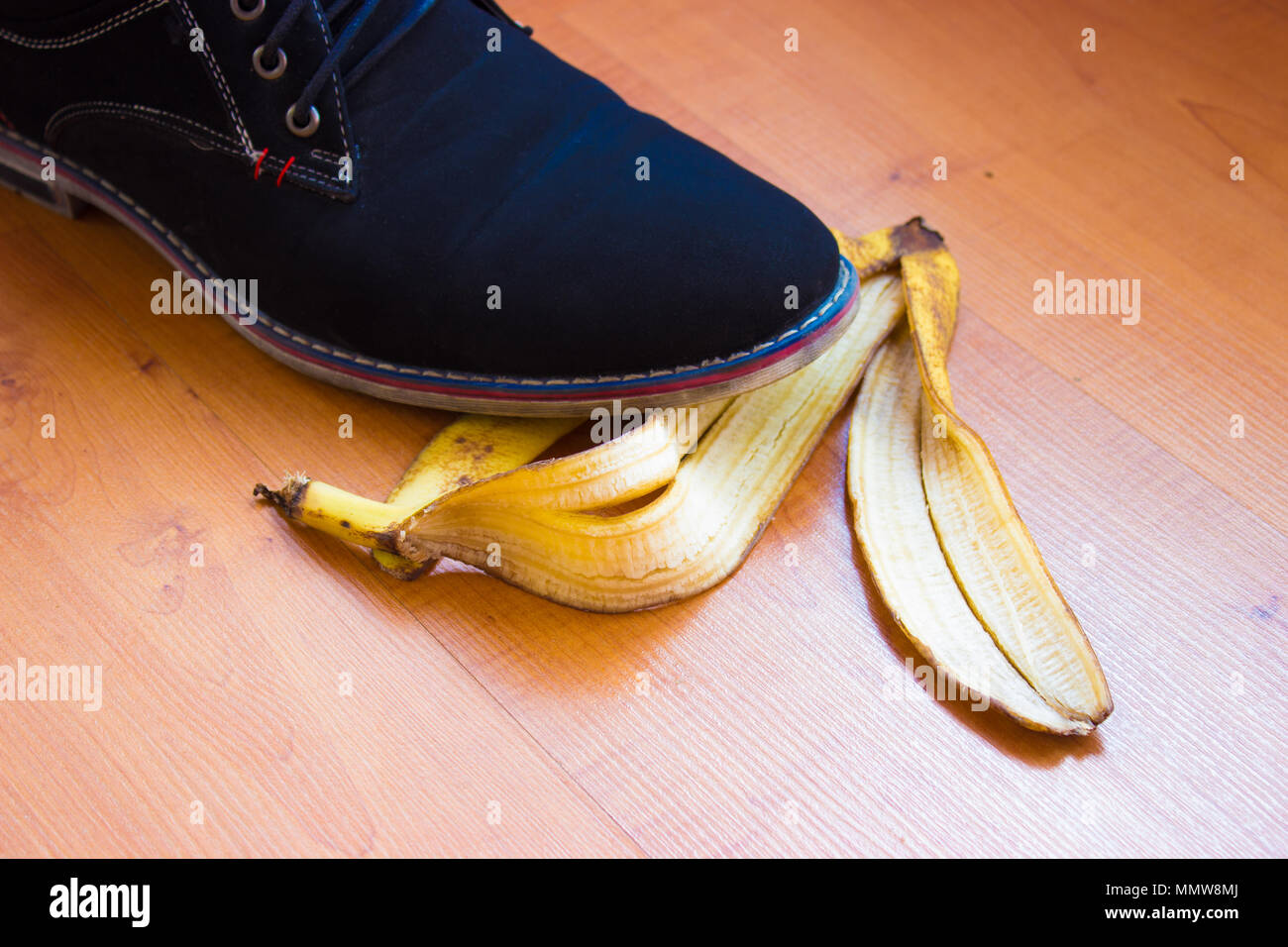 Blue shoe of young man slipped on a banana peel Stock Photo - Alamy