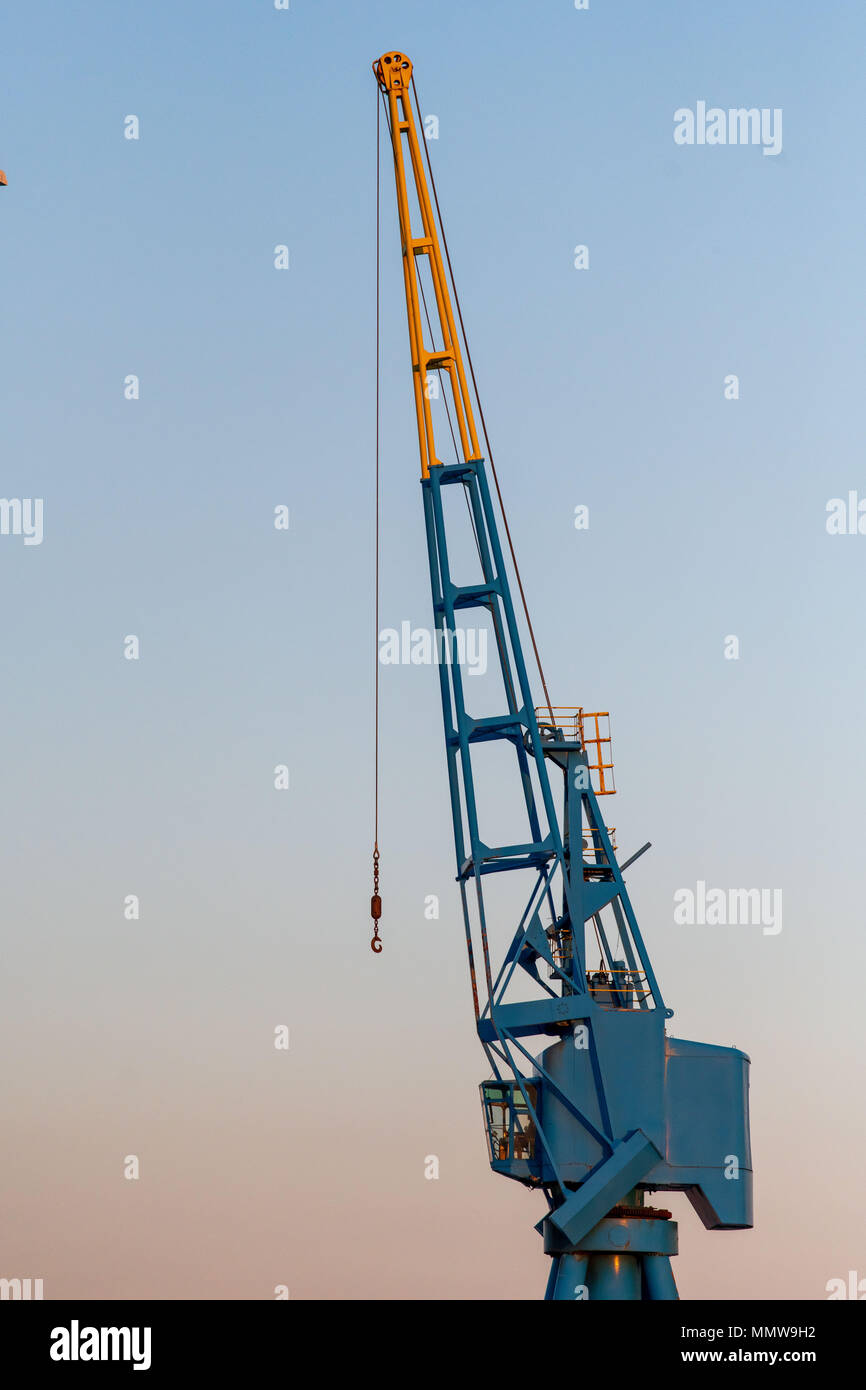 Two blue industrial cranes seen at a port in Cardiff, Wales, Uk, during ...