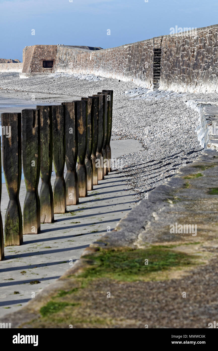 The wave & weather shaped wooden groyn poles & sea wall at Vazon Bay ...
