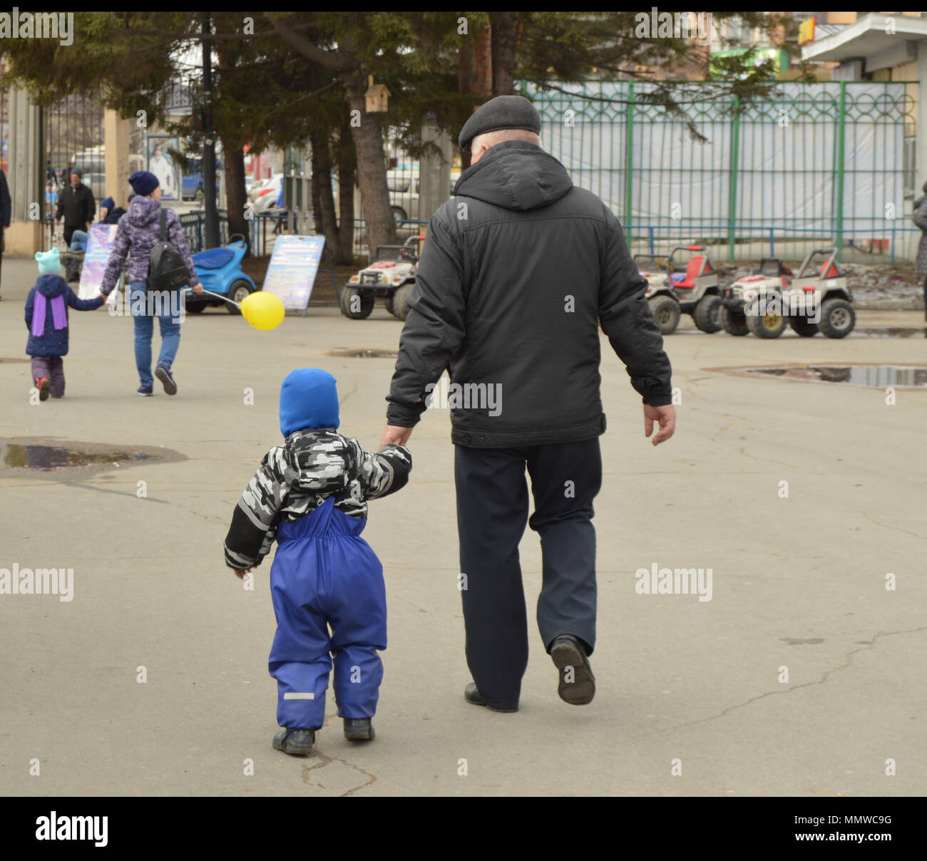 Grandfather and grandson walking in the city Park, taking care of ...