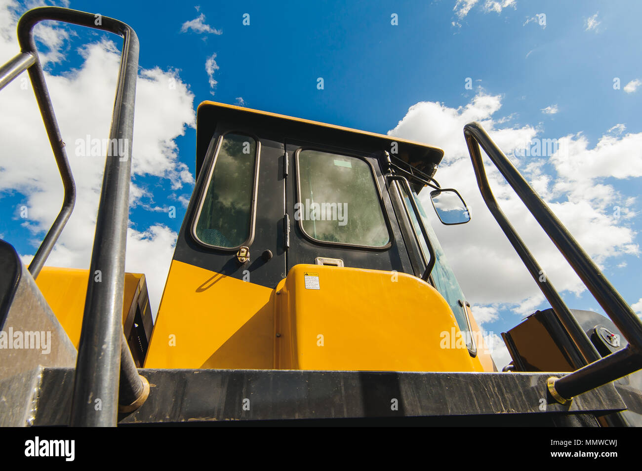 cabin front loader on a background of blue sky, steps on a tractor ...
