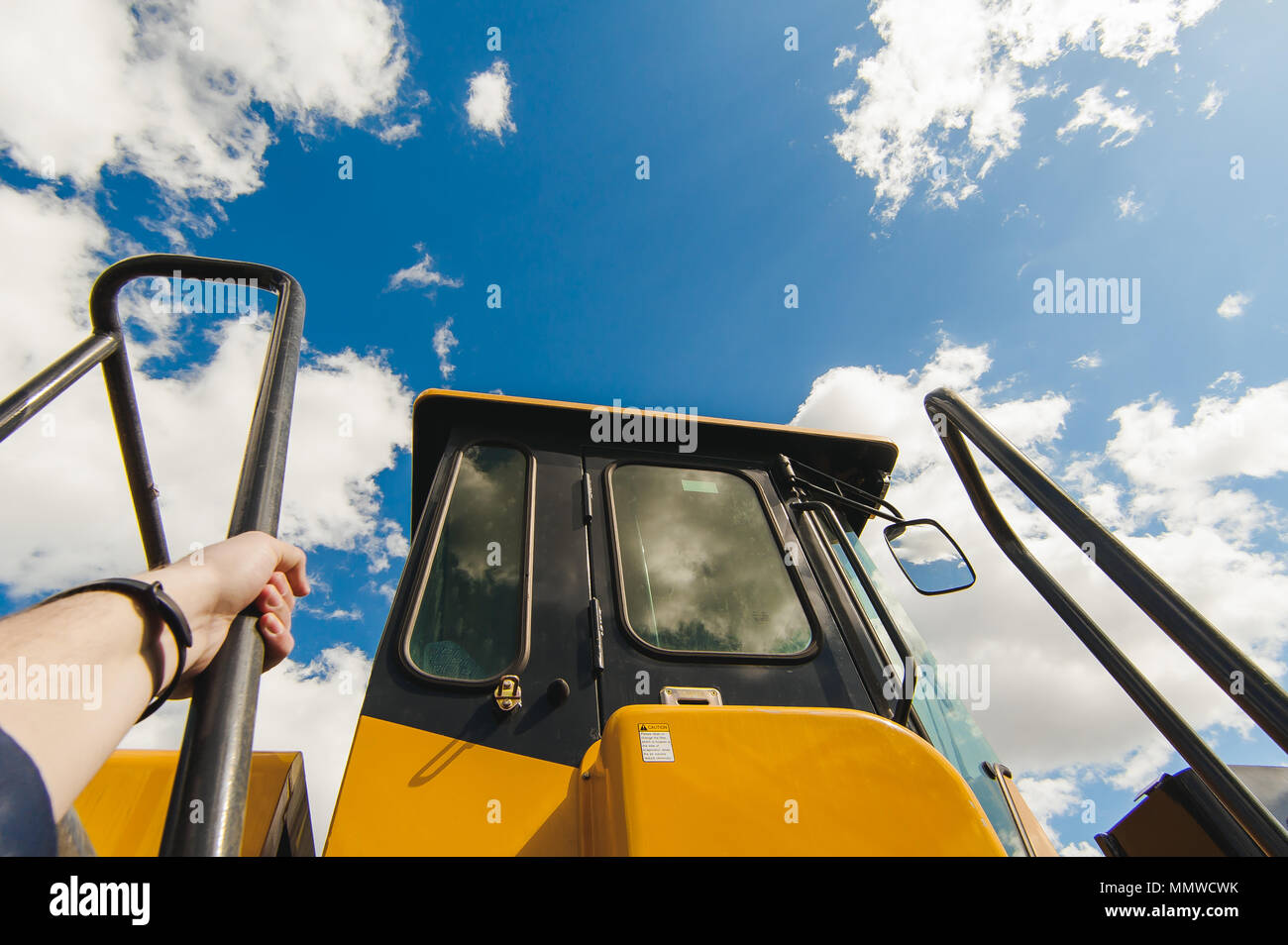 cabin front loader on a background of blue sky, steps on a tractor ...