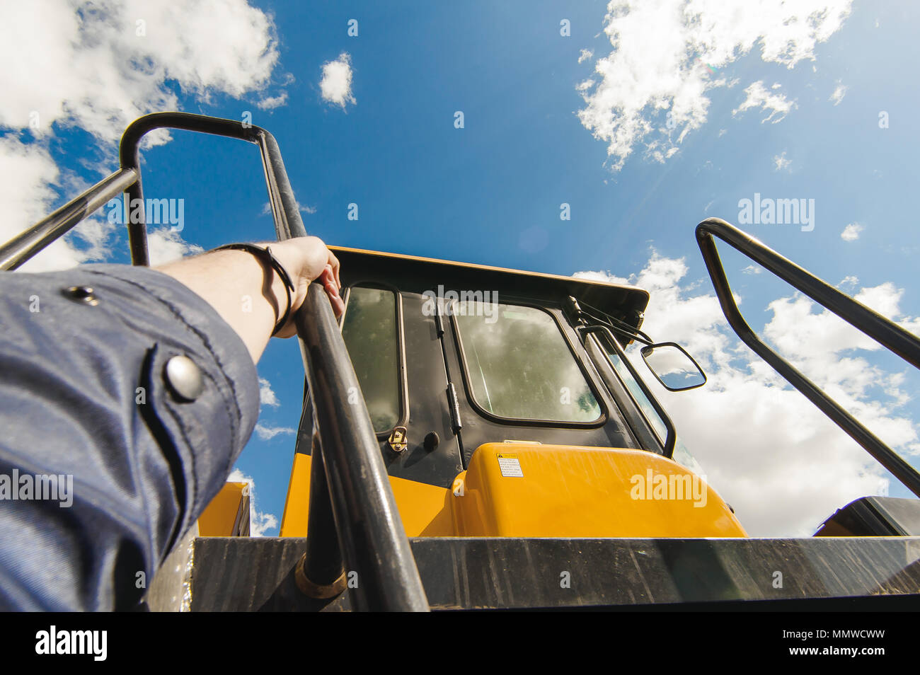 cabin front loader on a background of blue sky, steps on a tractor ...