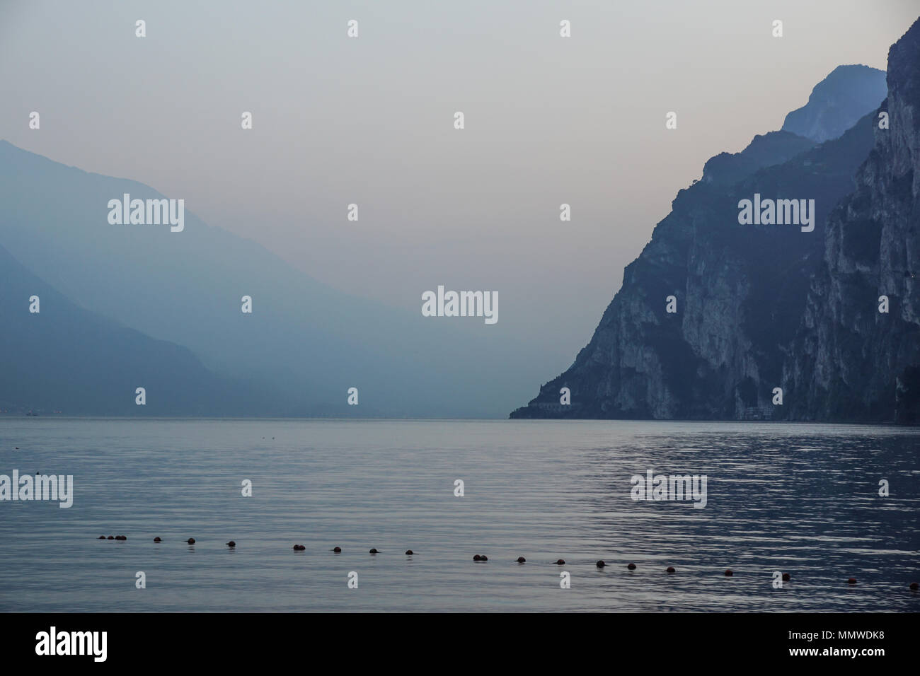 alpine landscape at sunset with lake beach and mountains on the horizon ...