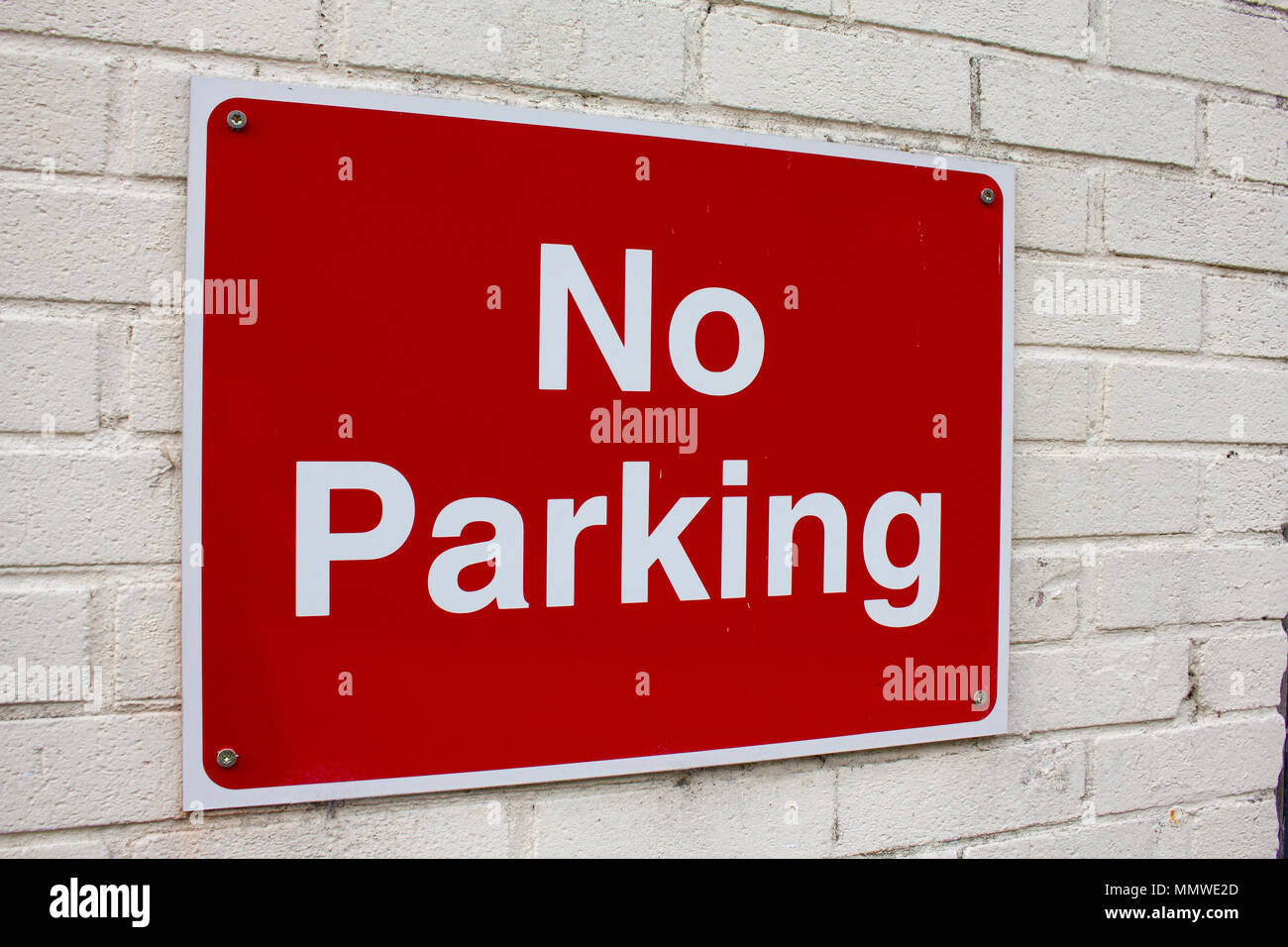 red, rectangular no parking sign with white lettering and a white ...