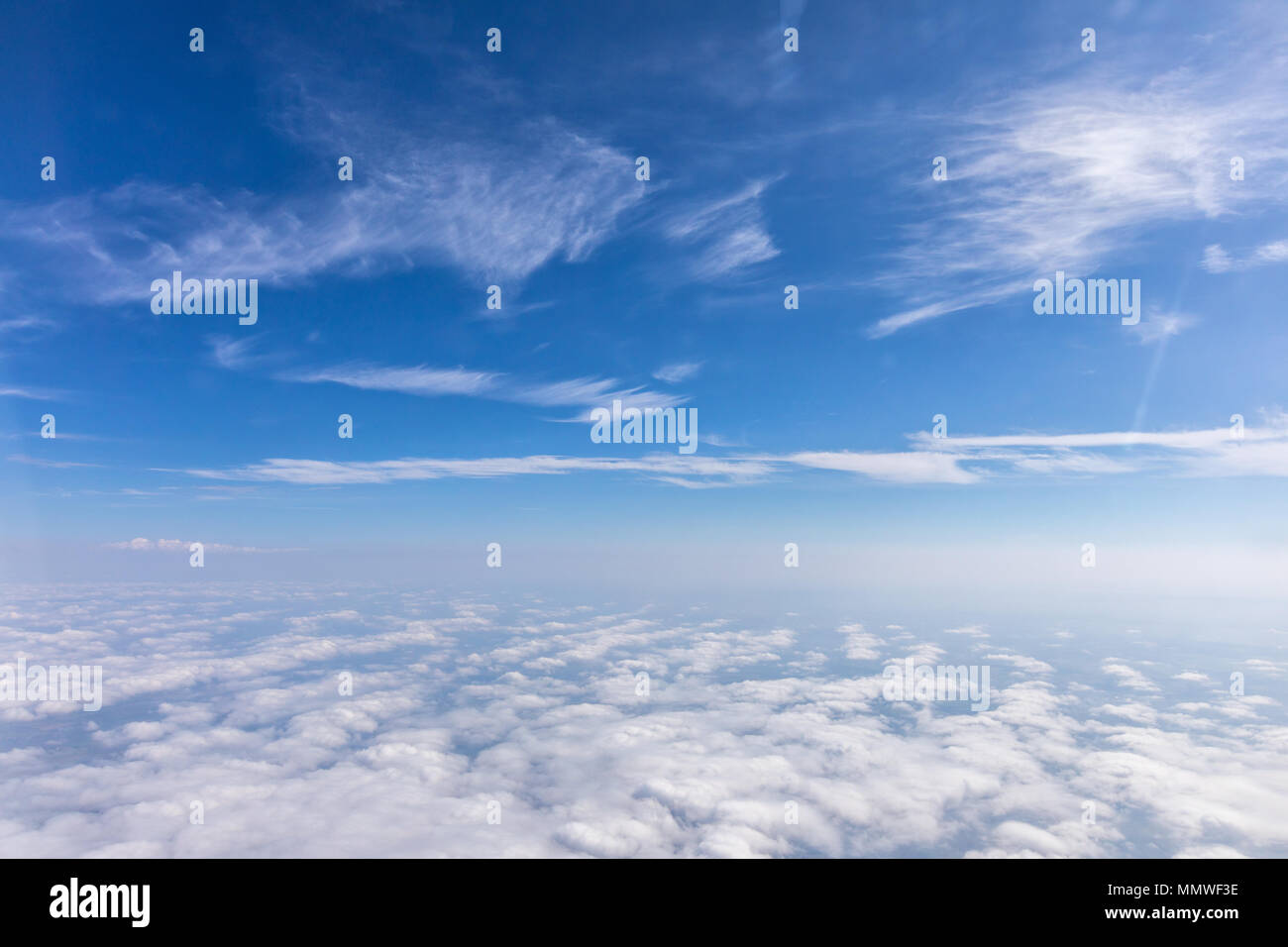 View from the airplane to the sky above the Alps mountains. Blue sky ...