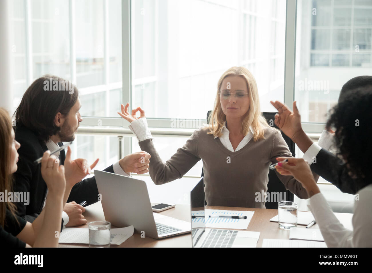 Calm businesswoman boss meditating ignoring multiracial employee Stock ...