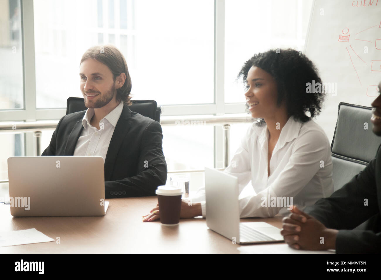 Multiracial smiling business people participating group meeting Stock ...