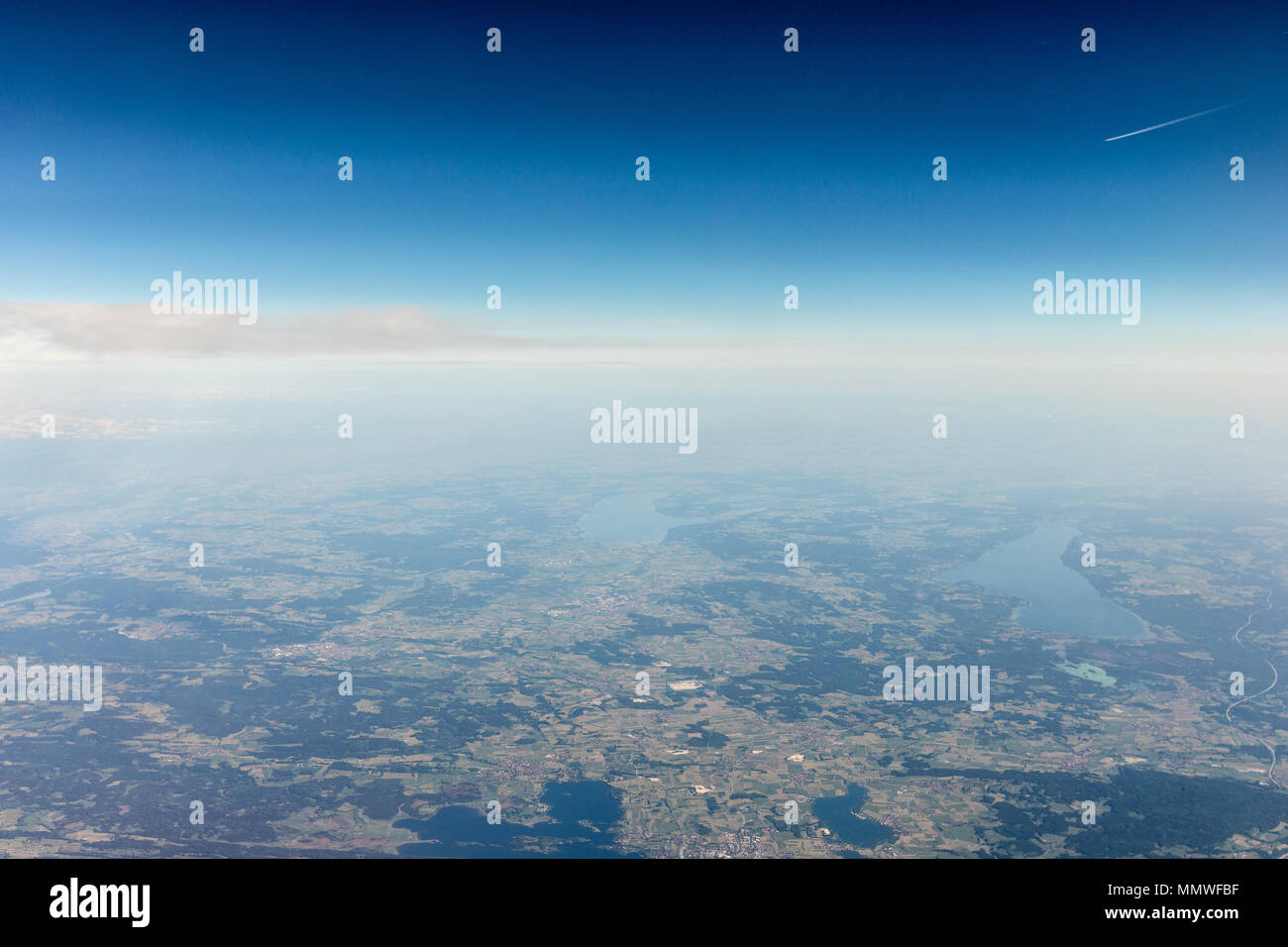 View from the airplane to the sky above the Alps mountains. Blue sky ...
